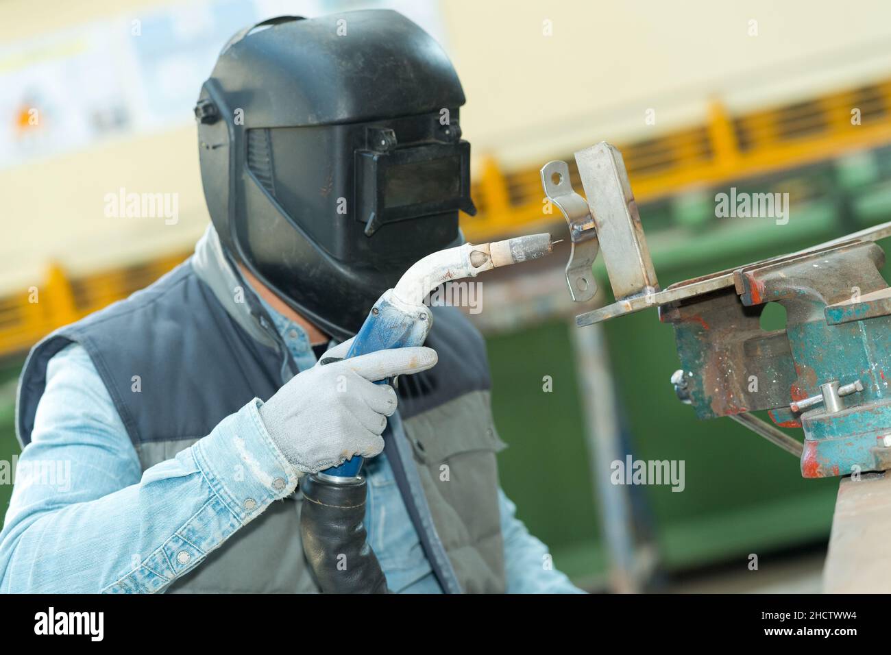 man welding metal held in vise Stock Photo - Alamy