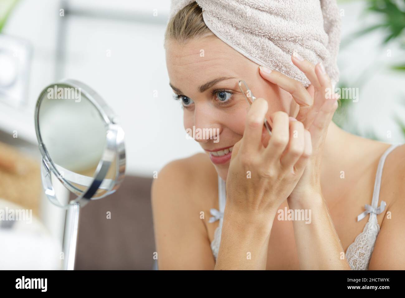 woman in cosmetics and facial care plugs her eyebrows Stock Photo - Alamy