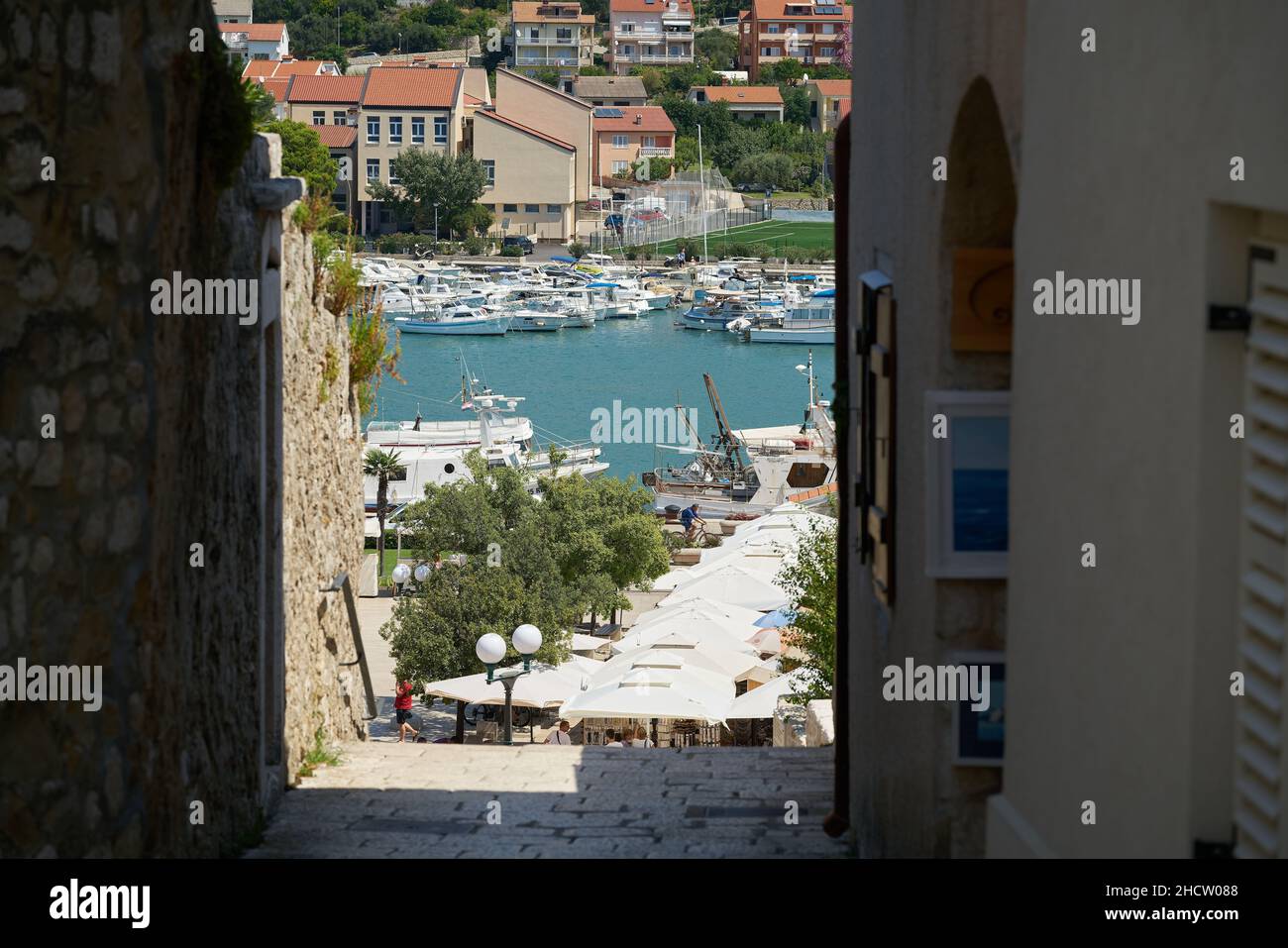 View through a narrow alley to the port of the town of Rab in Croatia ...