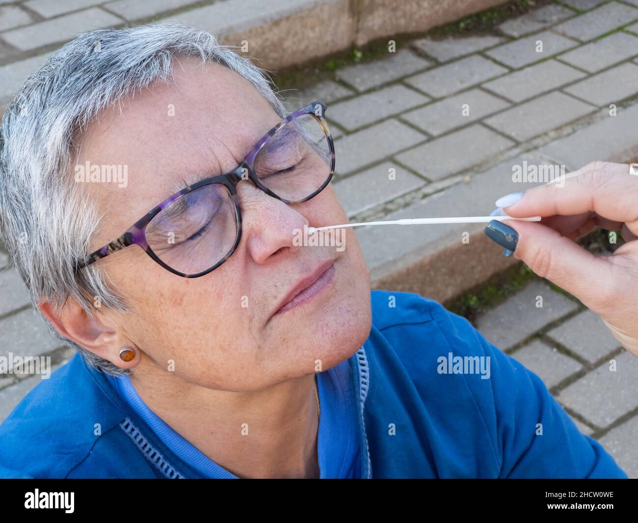 portrait of an adult woman taking an antigen test for covid-19 on the ...