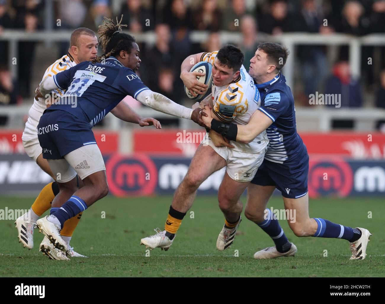 Wasps' Sam Spink (centre) is tackled by Sale Sharks' Marland Yarde ...
