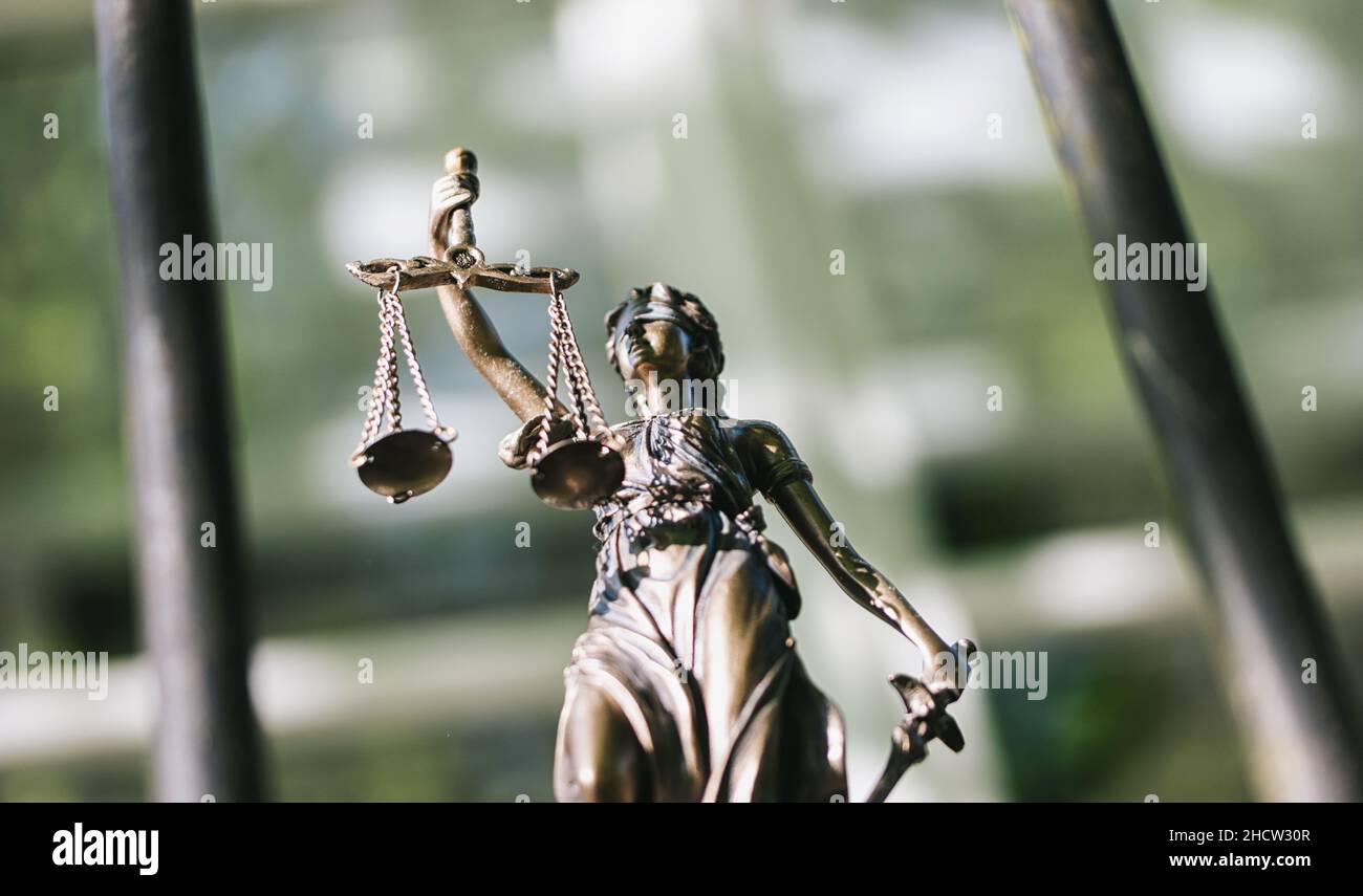 The Statue of Justice symbol against a prison grid, legal law concept ...