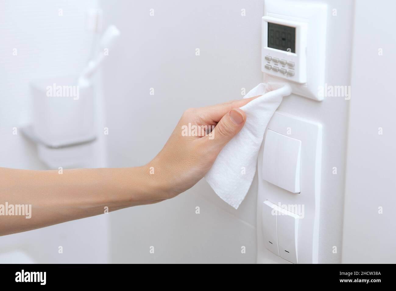 Cleaning switches and sockets with a microfiber cloth. Woman hand using ...