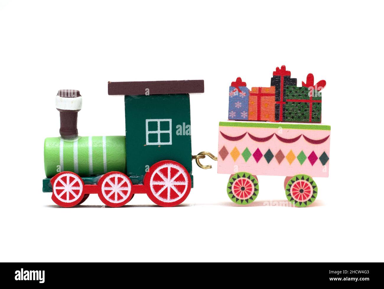 A toy steam locomotive carries a wagon with gifts. Feast of the ...