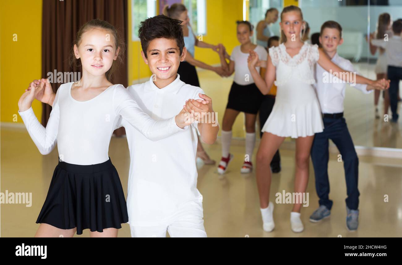 Group of smiling children dancing salsa in school Stock Photo - Alamy