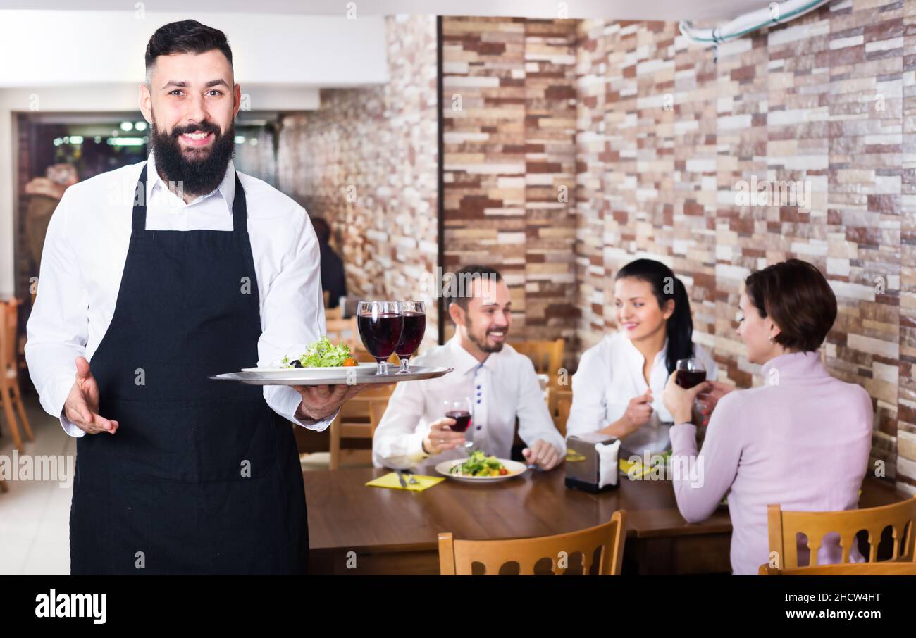 Waiter serving restaurant guests Stock Photo - Alamy