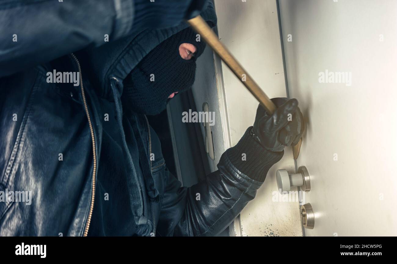 burglar with crowbar breaking and entering a house door at night Stock ...