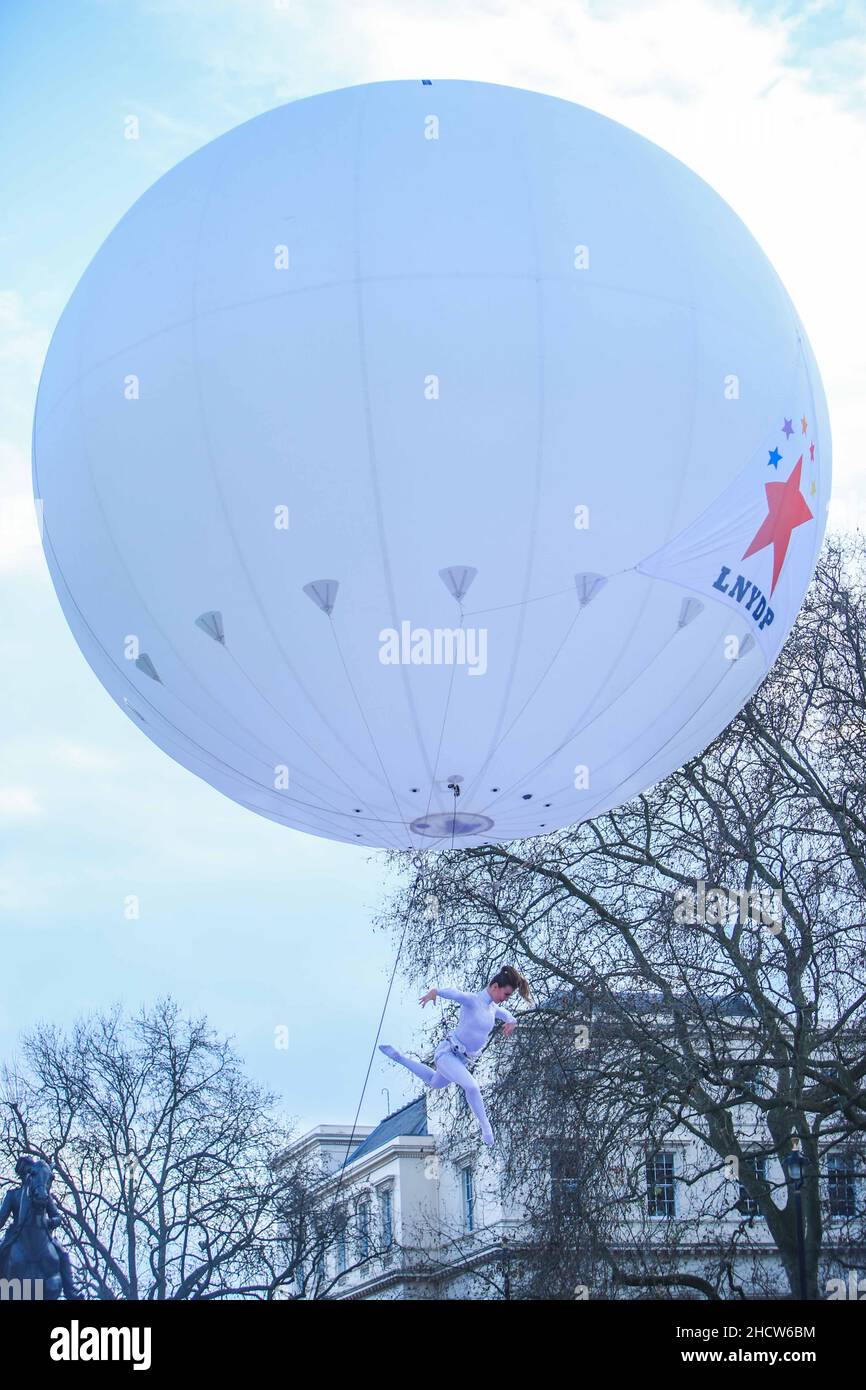 Acrobat hanging from a helium baloon hi-res stock photography and ...
