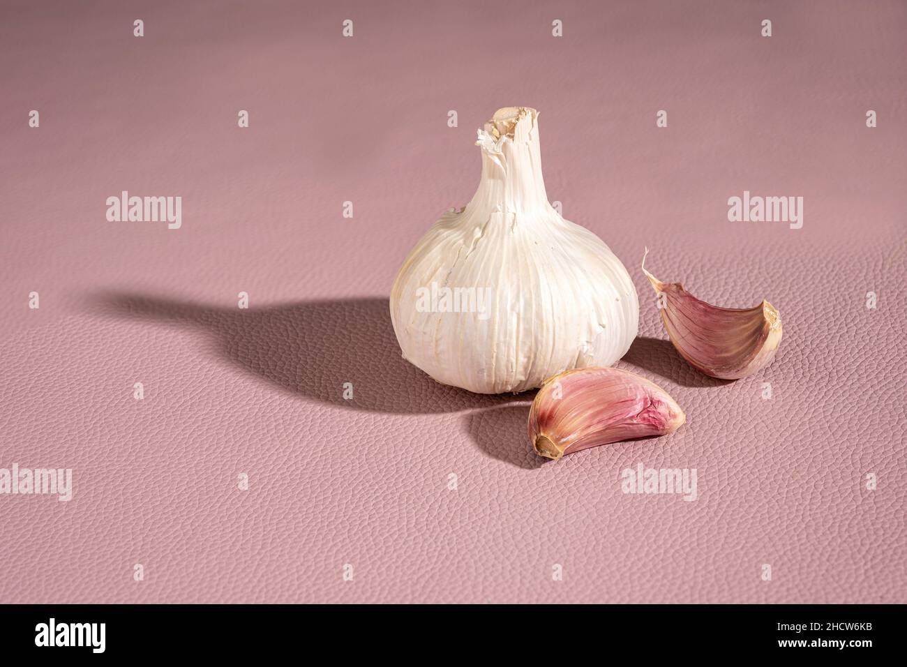 Purple garlic bulb and cloves on pink background, horizontal Stock ...