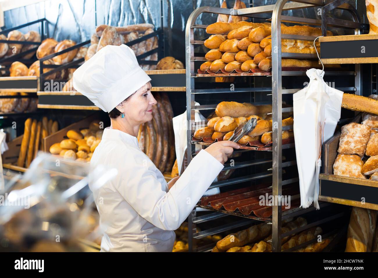Bakery mature female employee with tasty bread products Stock Photo - Alamy