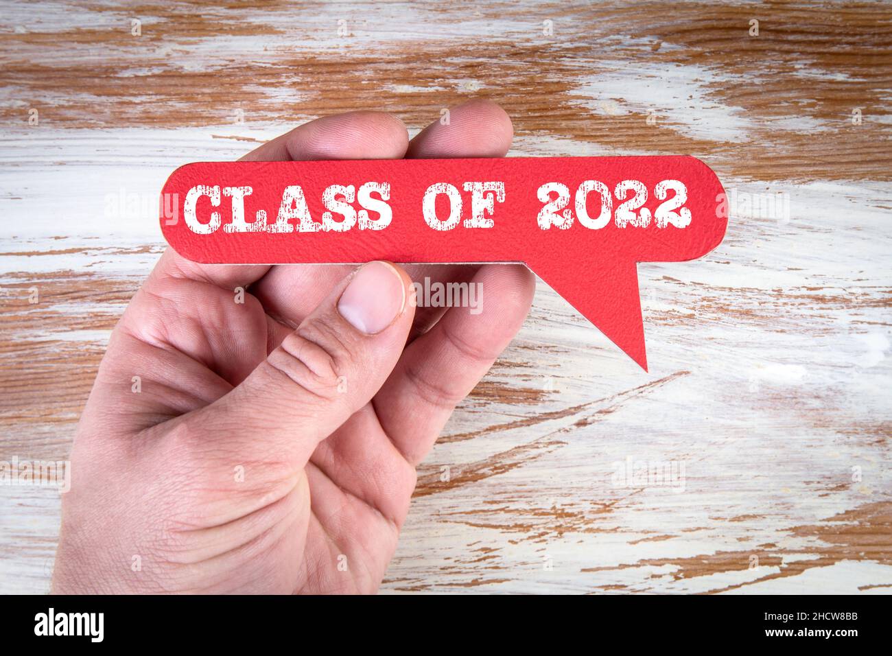Class of 2022. Red speech bubble with text on a white wooden background ...