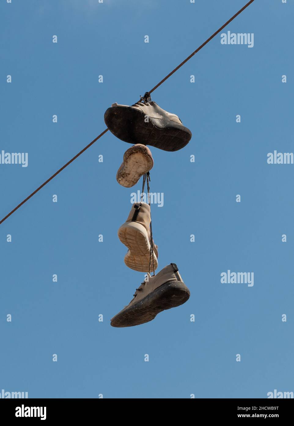 shoes hanging from electrical wires in the sky close-up Stock Photo - Alamy