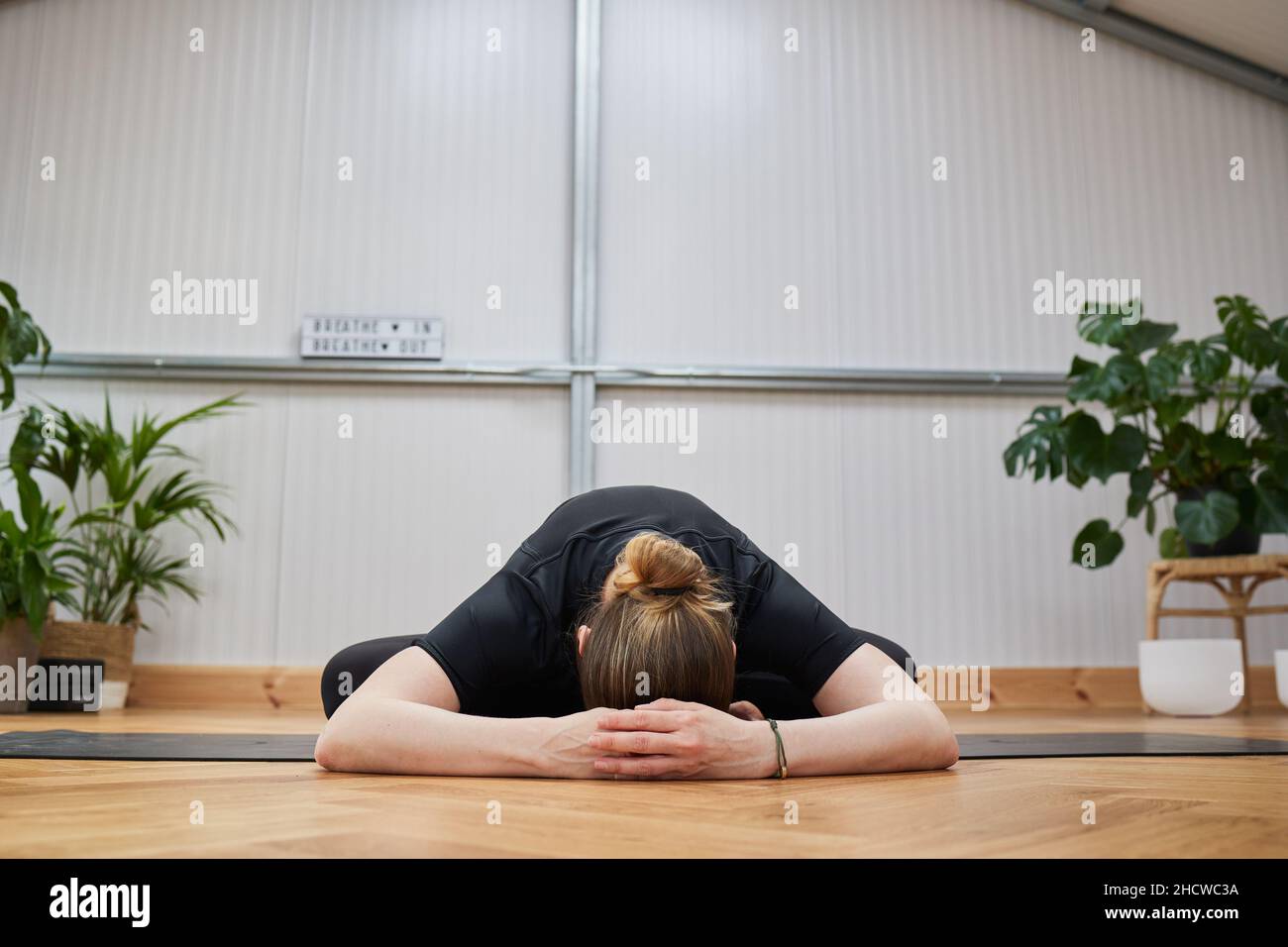 flexible woman lying on the envelope of a mat practicing yoga Stock ...
