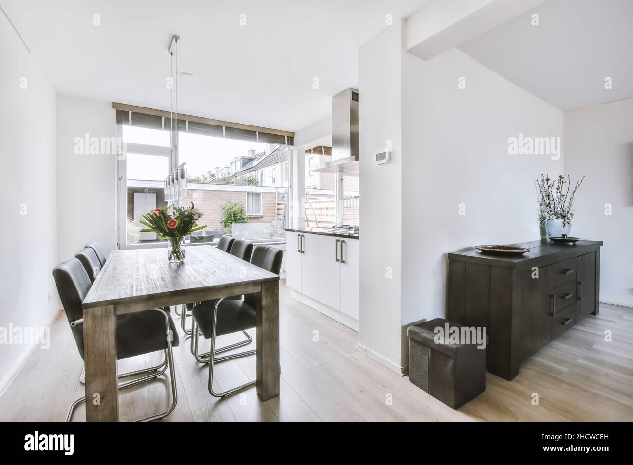 White large luxury modern kitchen with dark chairs Stock Photo - Alamy