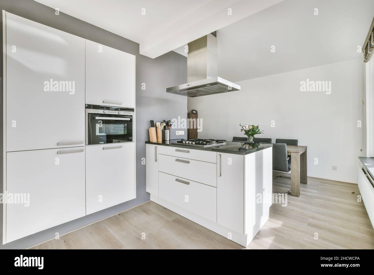White large luxury modern kitchen with dark chairs Stock Photo - Alamy