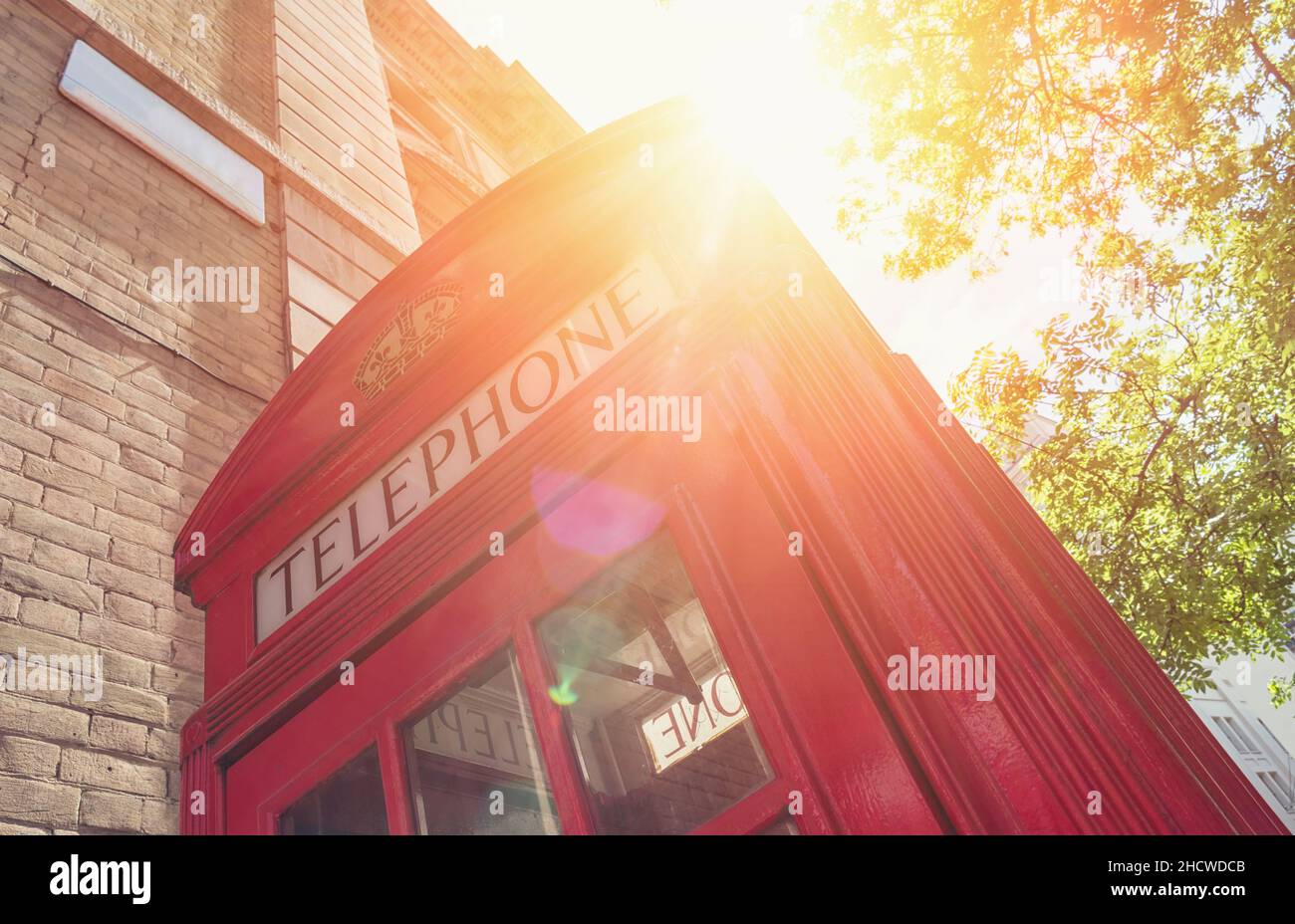 Red Telephone Booth with sun at summer in London street Stock Photo - Alamy