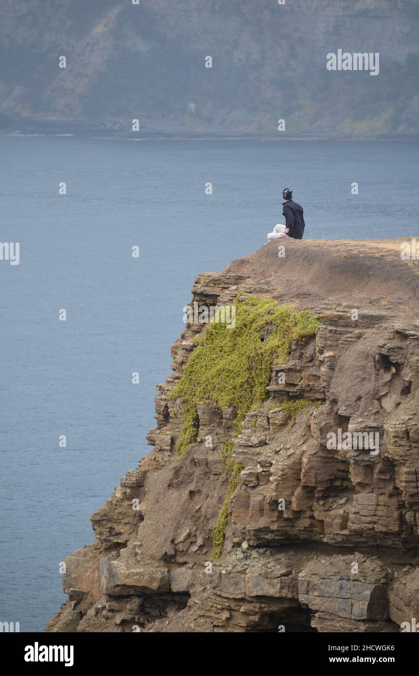 Person sitting cliff edge hi-res stock photography and images - Alamy