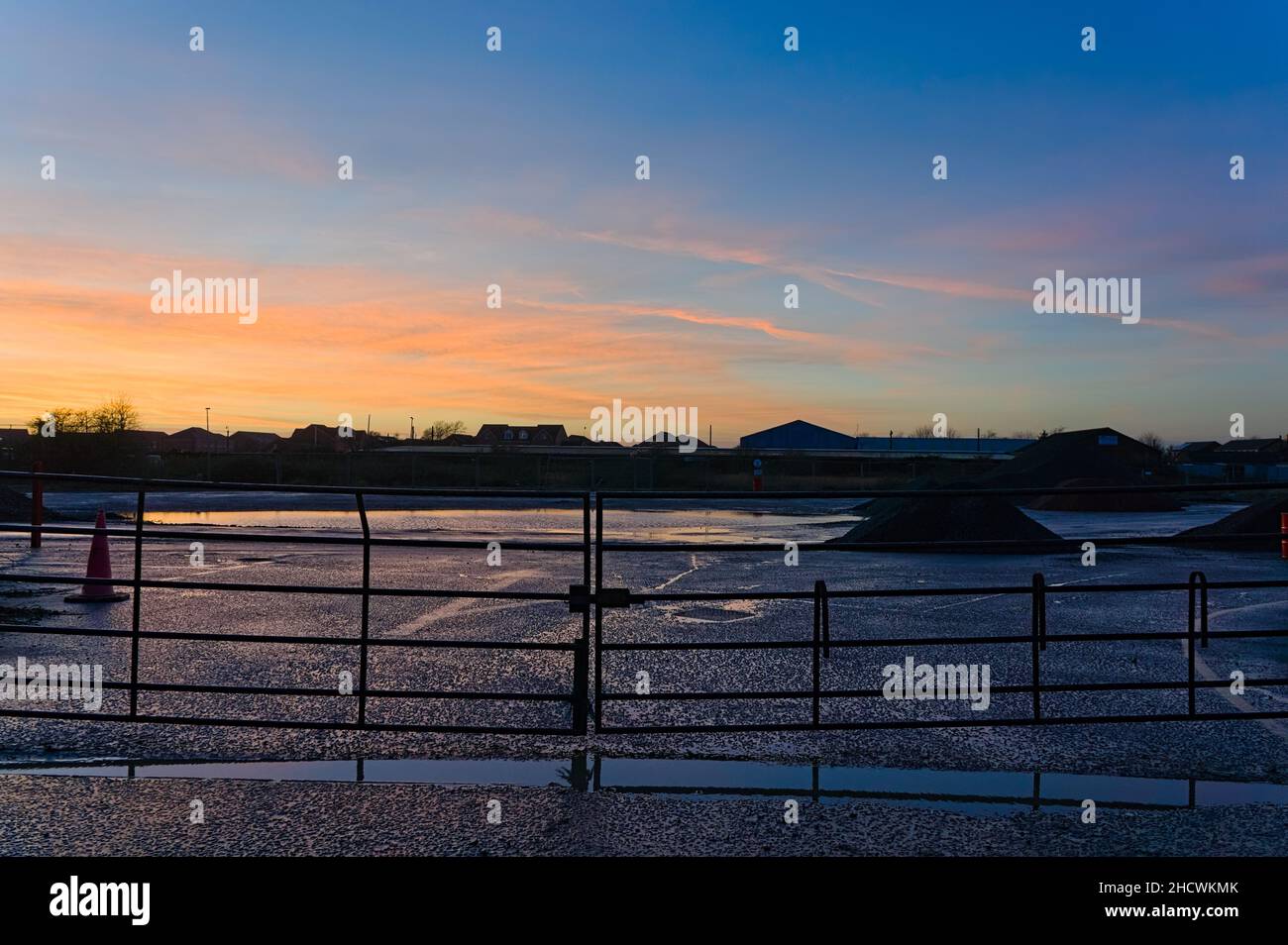 Stunning sunset sky over an empty building site closed off with steel ...