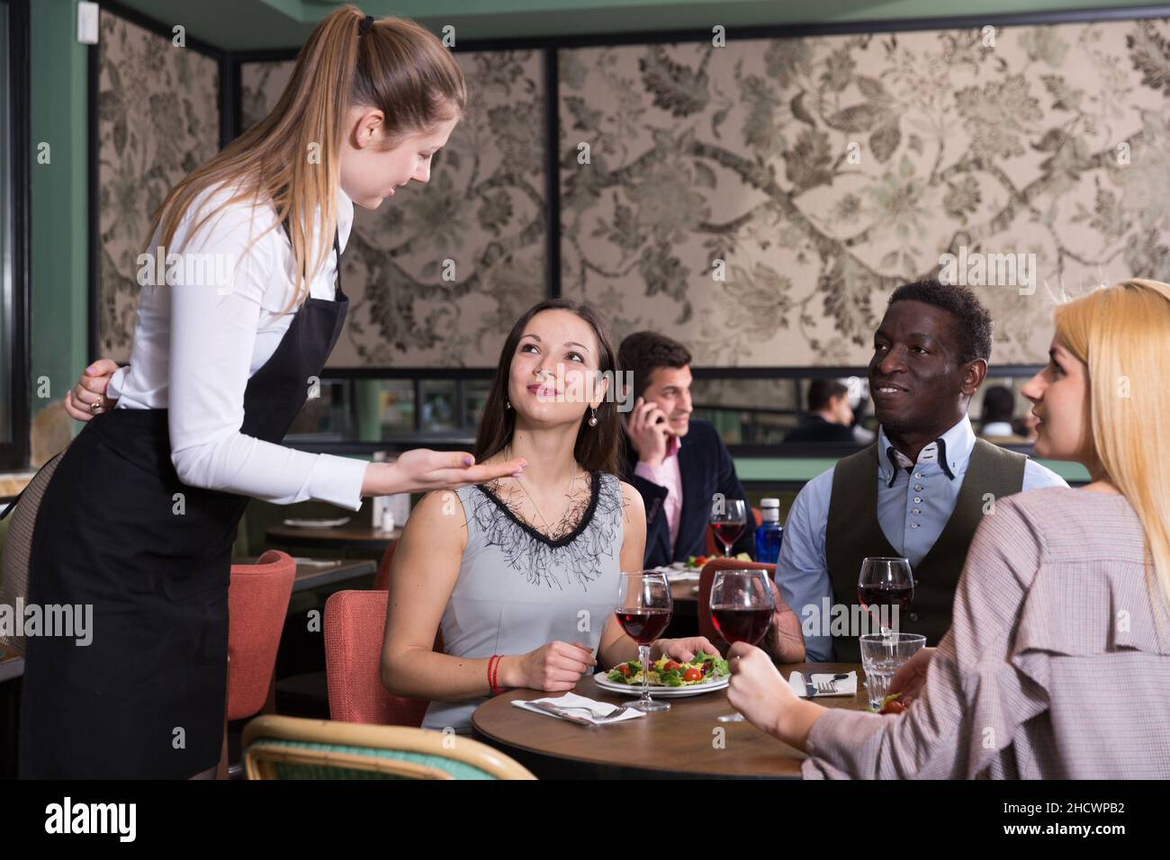 Waitress talking with satisfied guests Stock Photo - Alamy