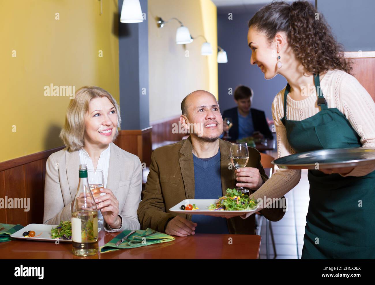 Happy waitress taking order at table Stock Photo - Alamy