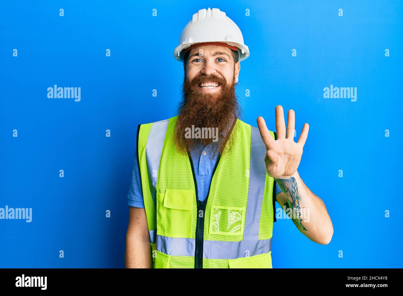 Redhead man with long beard wearing safety helmet and reflective jacket ...