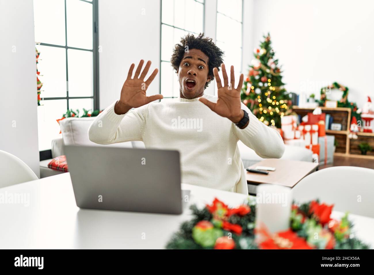 Young african american man using laptop sitting on the table by ...