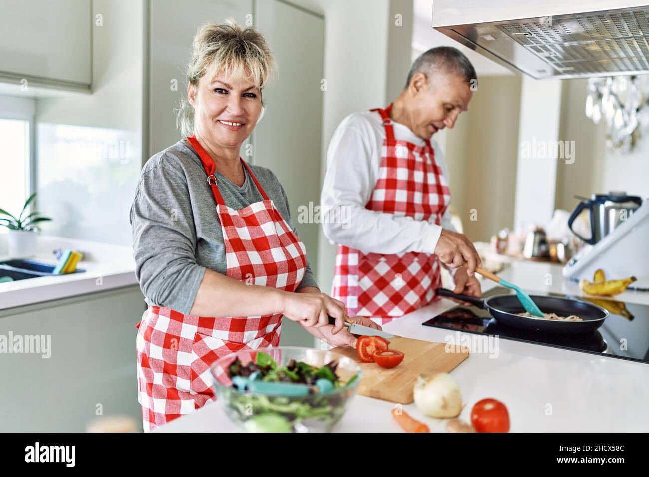Senior caucasian couple smiling happy cooking at the kitchen Stock ...