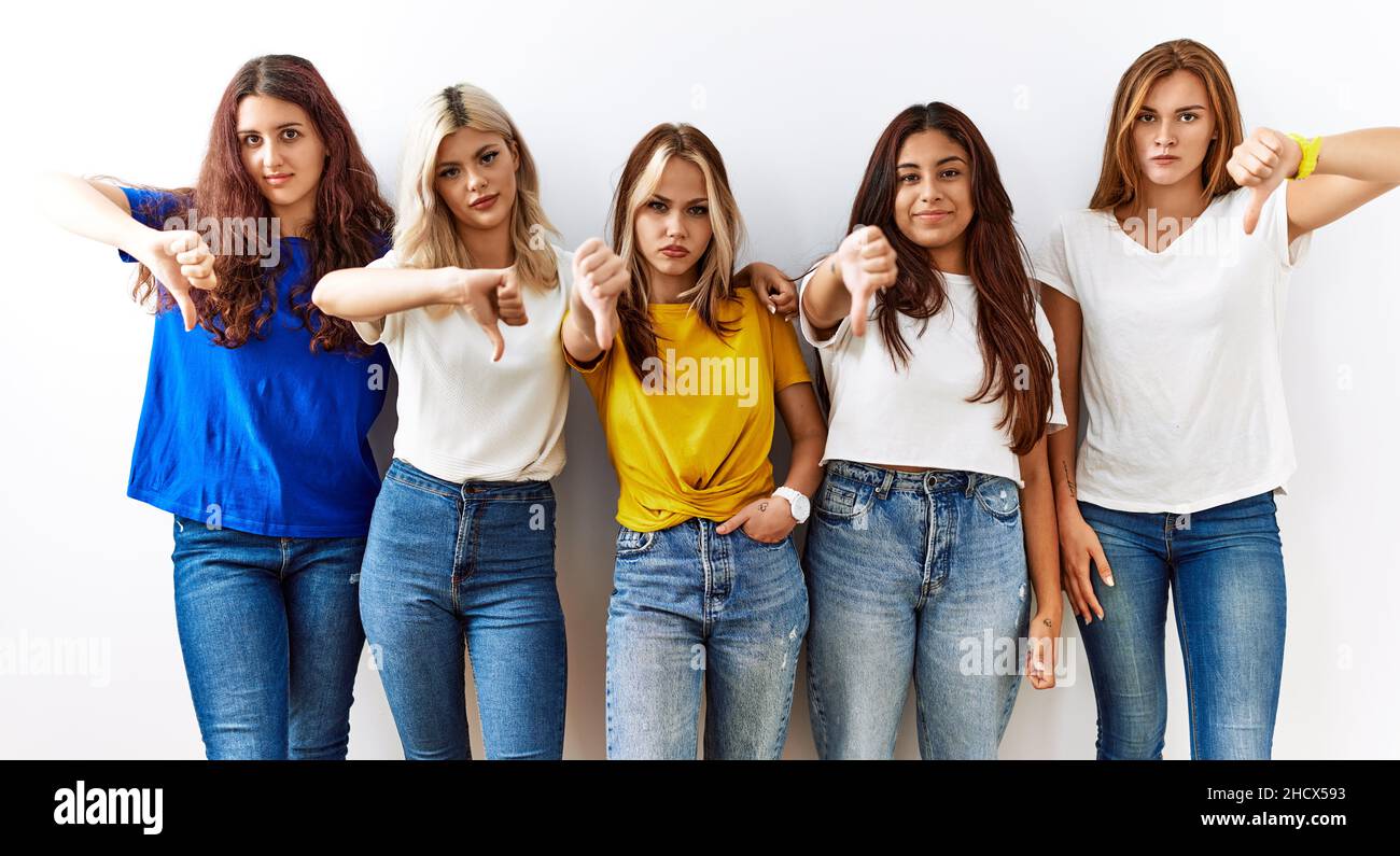 Group of young girl friends standing together over isolated background ...