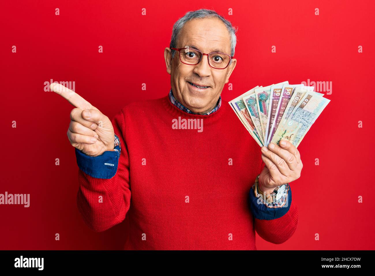 Handsome senior man with grey hair holding egyptian pounds banknotes ...