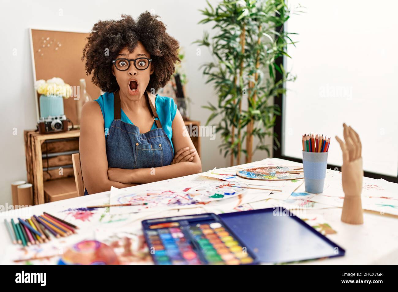 Beautiful african american woman with afro hair painting at art studio ...
