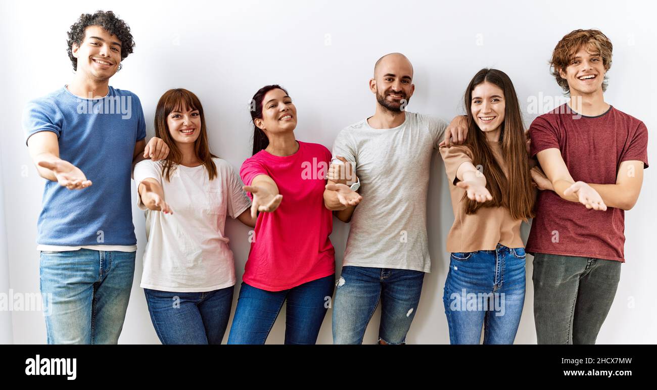 Group of young friends standing together over isolated background ...