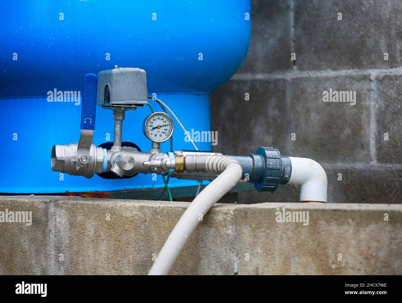 Deep water well set up. Water pressure gauge and storage tank Stock ...