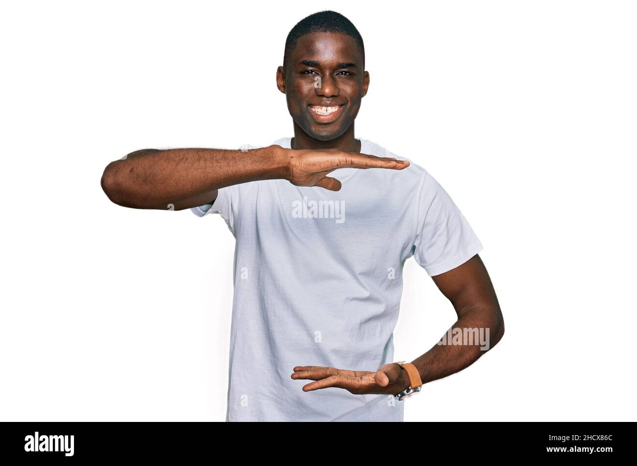 Young african american man wearing casual white t shirt gesturing with ...