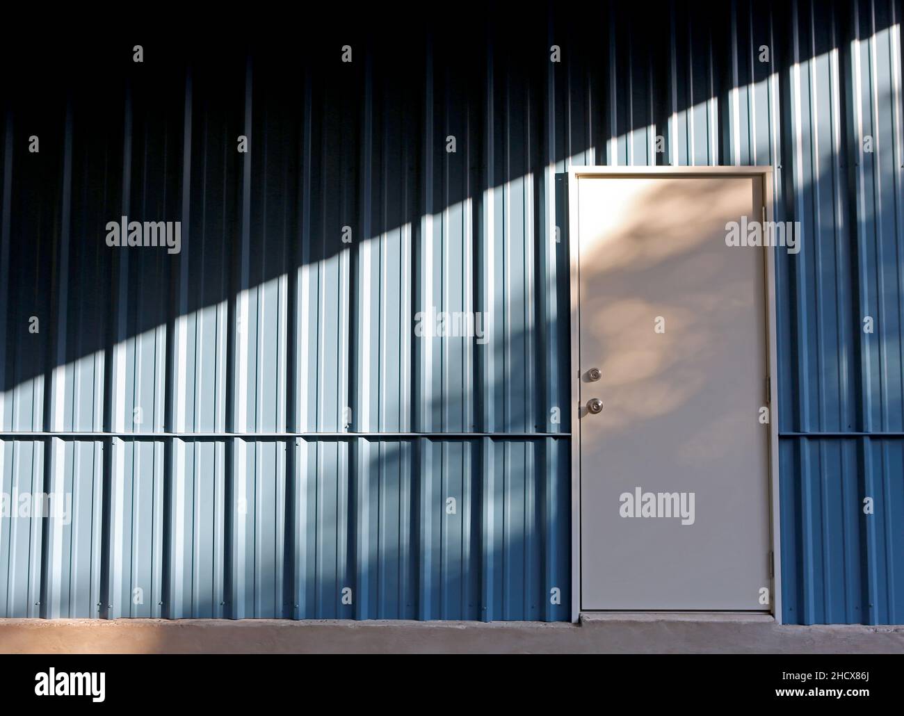 Metal building background. Steel Building wall with door and light ...