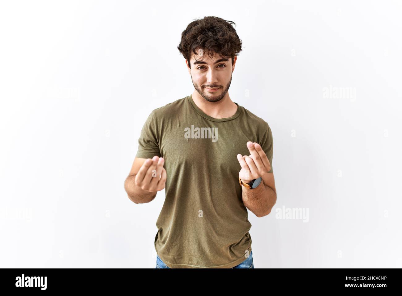 Hispanic man standing over isolated white background doing money ...