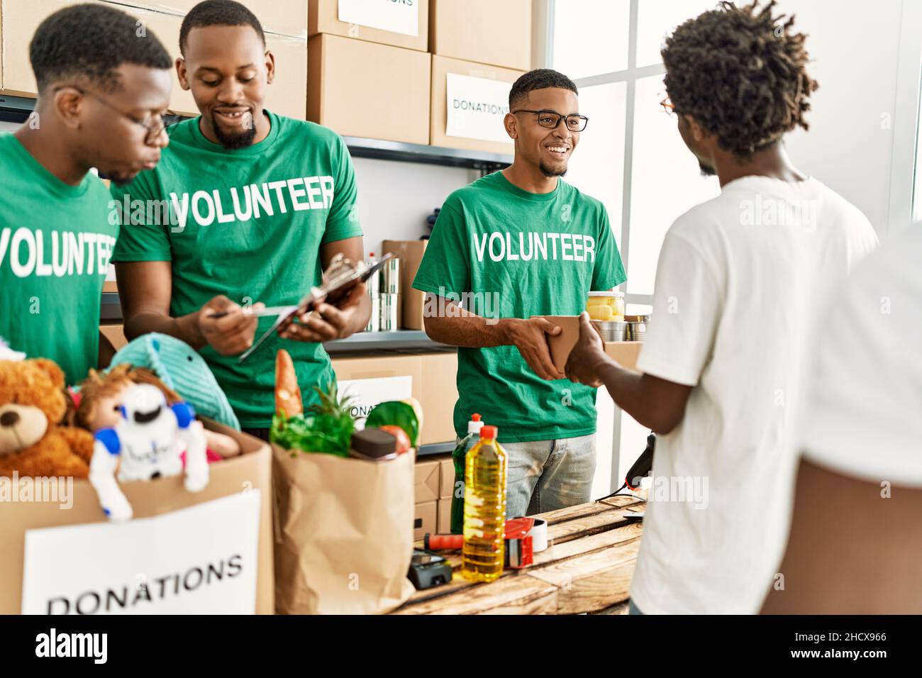 Group of young african american volunteers helping people at charity ...