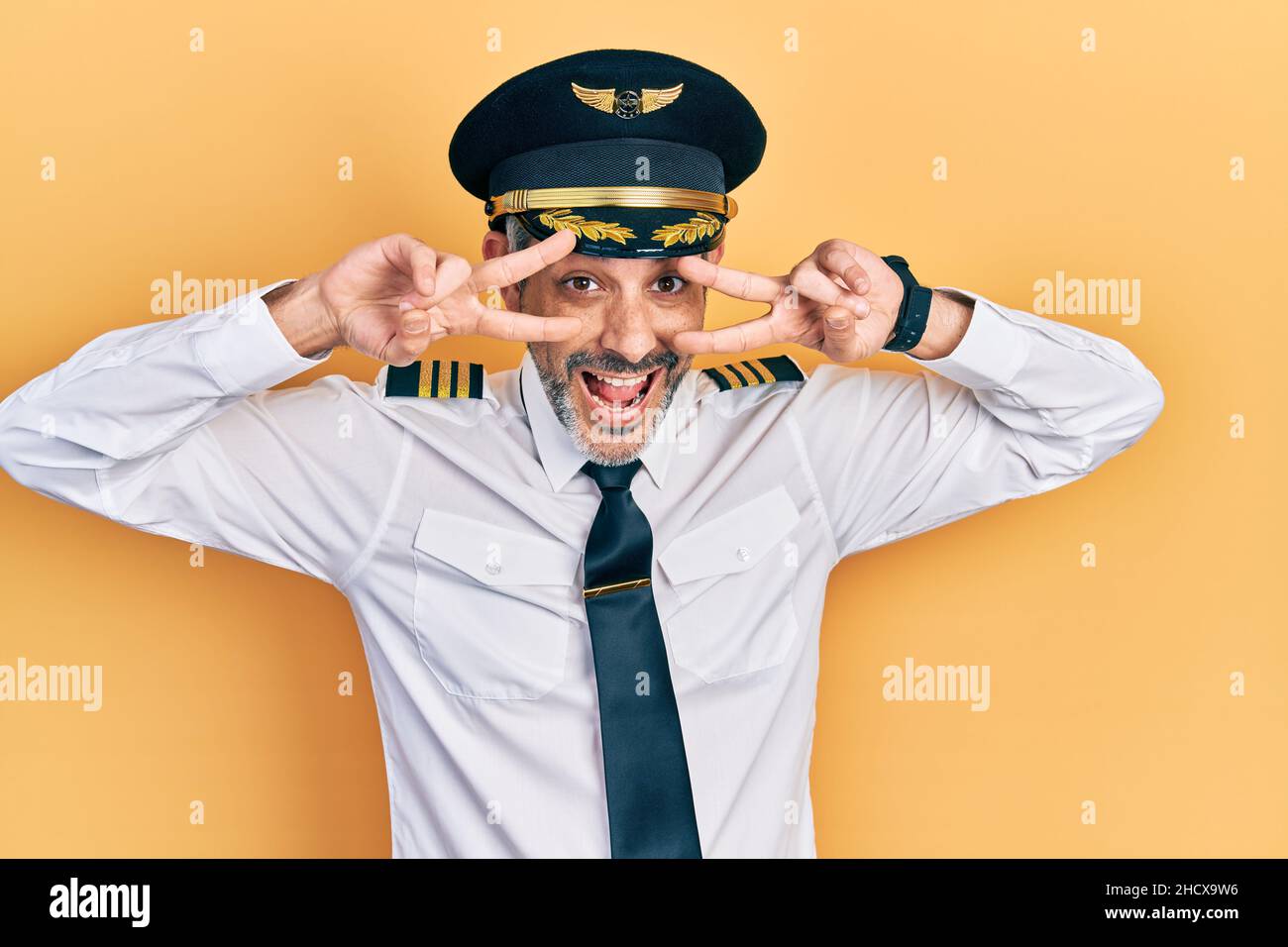 Handsome middle age man with grey hair wearing airplane pilot uniform ...