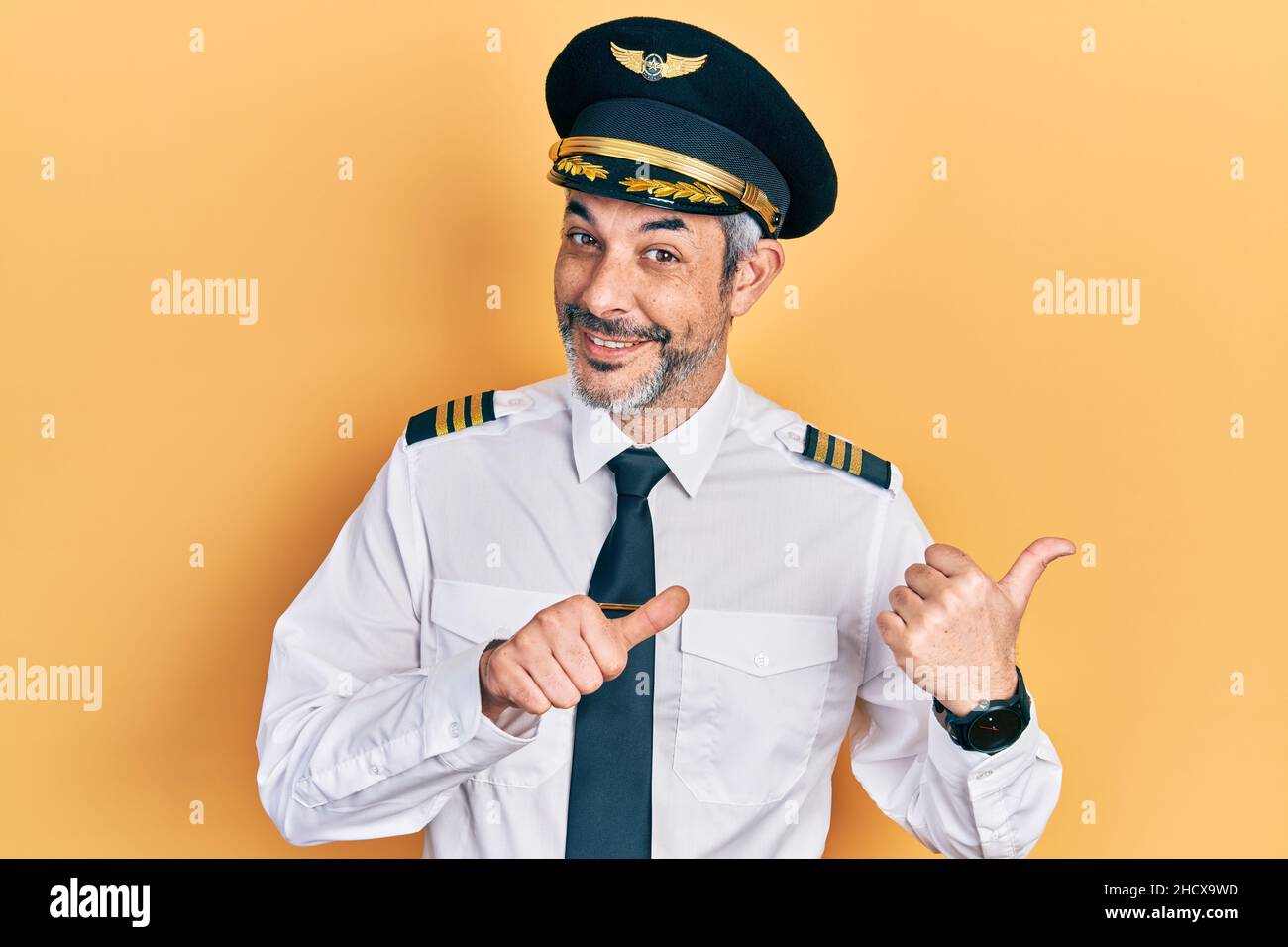 Handsome middle age man with grey hair wearing airplane pilot uniform ...