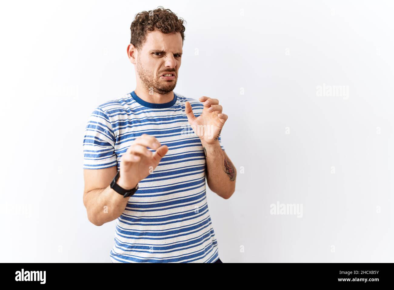 Handsome young man standing over isolated background disgusted ...