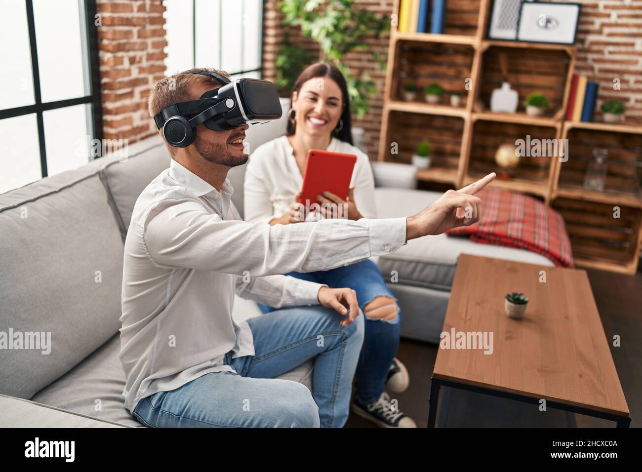 Man and woman couple using touchpad and vr goggles at home Stock Photo ...