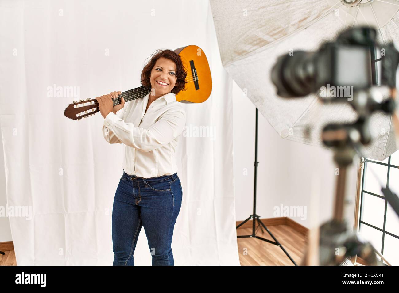 Beautiful guitarist model posing front professional camera holding ...