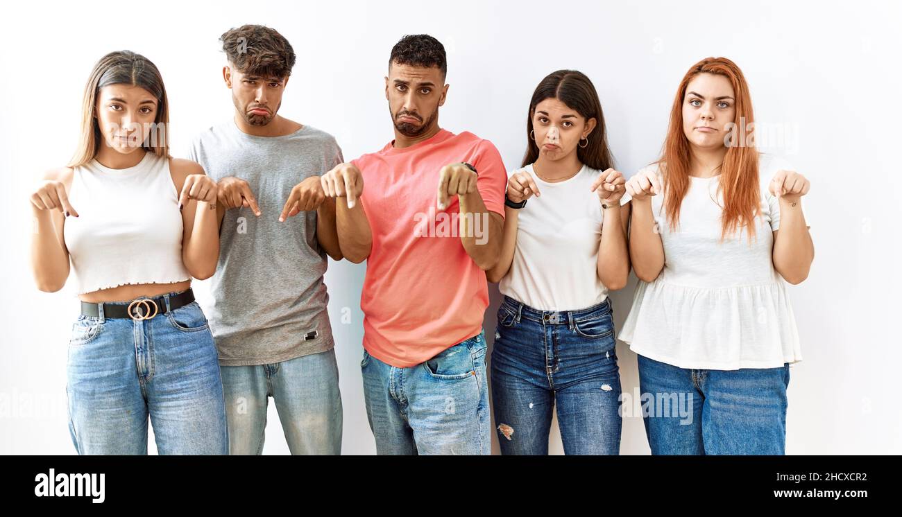 Group of young friends standing together over isolated background ...