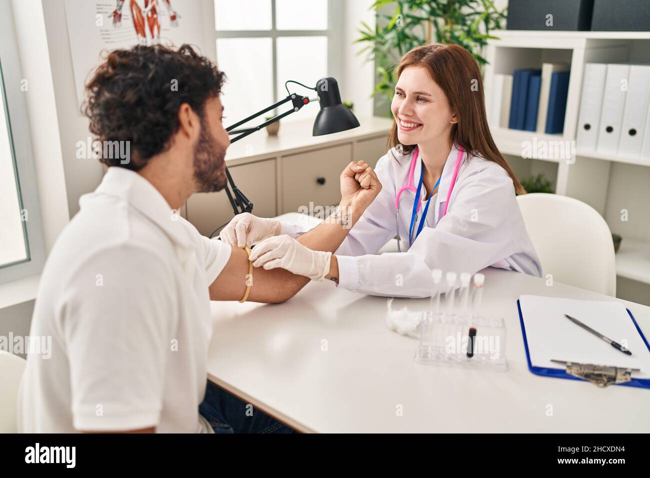 Man and woman wearing doctor uniform having blood analysis at clinic ...