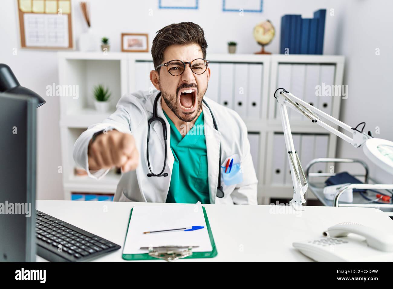 Young man with beard wearing doctor uniform and stethoscope at the ...