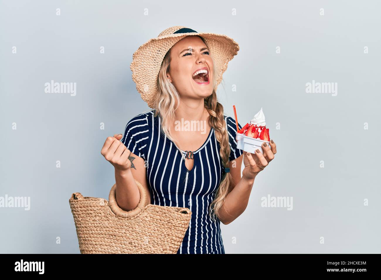 Beautiful young blonde woman wearing summer style eating ice cream ...