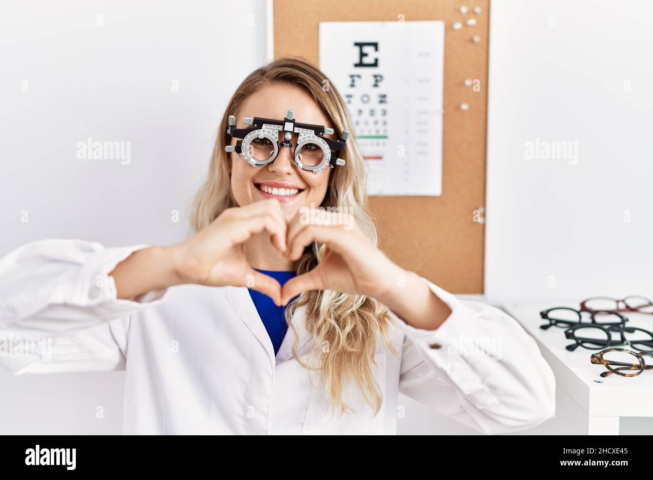 Young beautiful optician woman wearing optometry glasses at the clinic ...