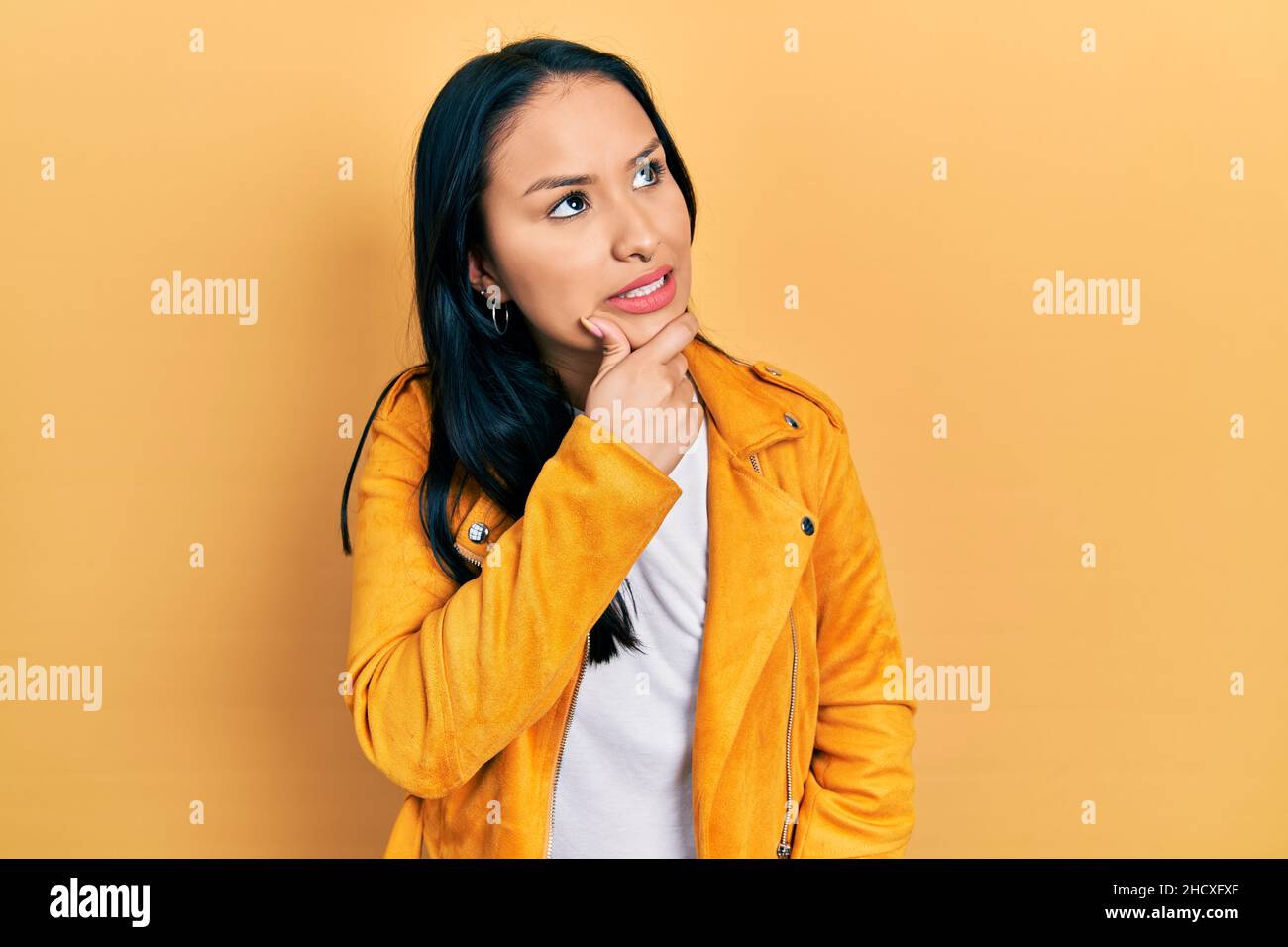 Beautiful hispanic woman with nose piercing wearing yellow leather ...