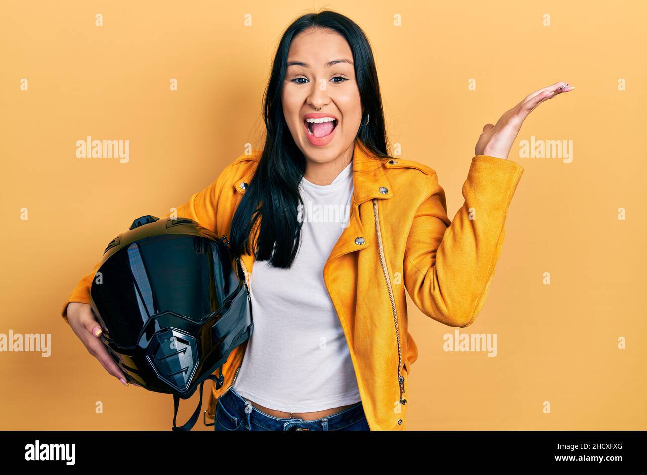 Beautiful hispanic woman with nose piercing holding motorcycle helmet ...