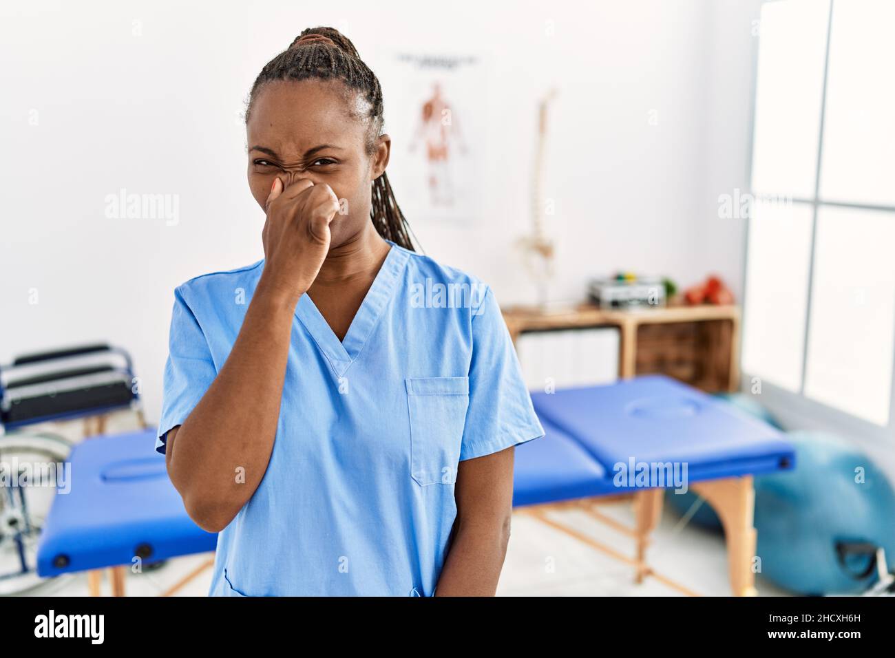 Black woman with braids working at pain recovery clinic smelling ...