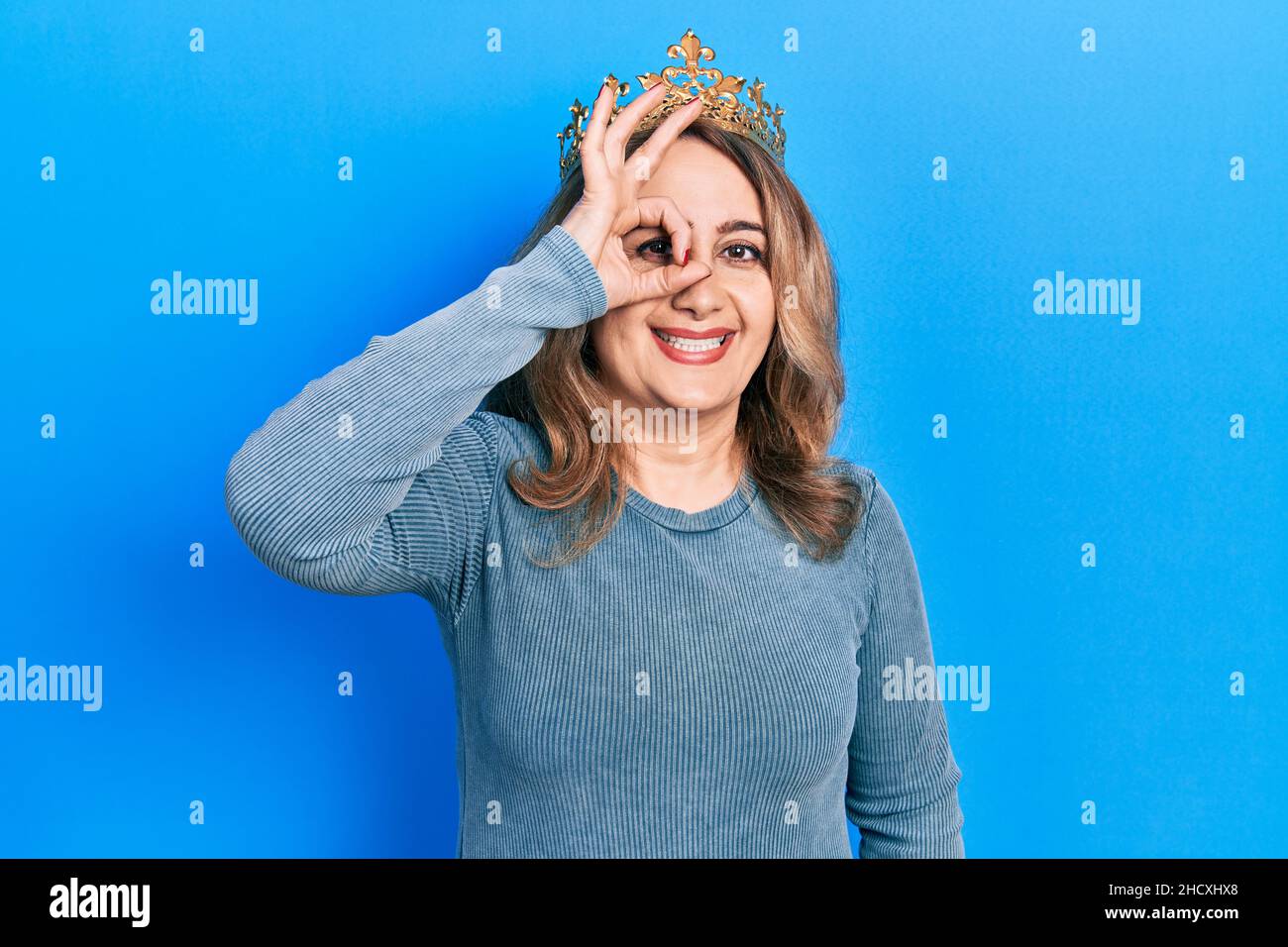 Middle age caucasian woman wearing queen crown doing ok gesture with ...
